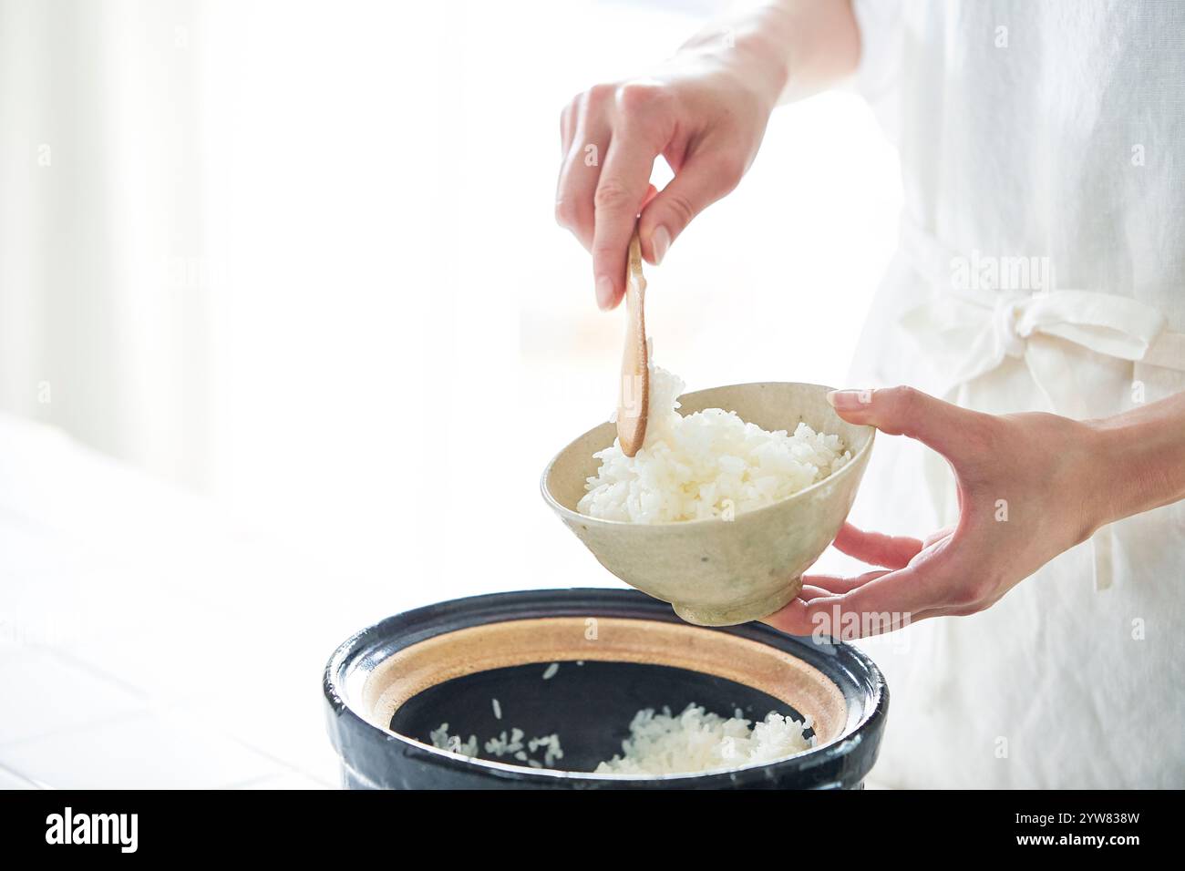 Woman cooking rice in earthen pot Stock Photo - Alamy