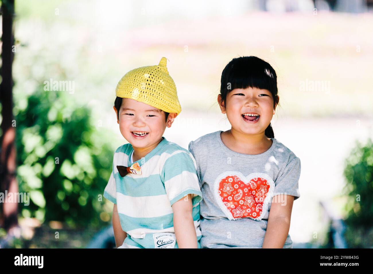 Boy and girl laughing in the shade of a tree Stock Photo - Alamy