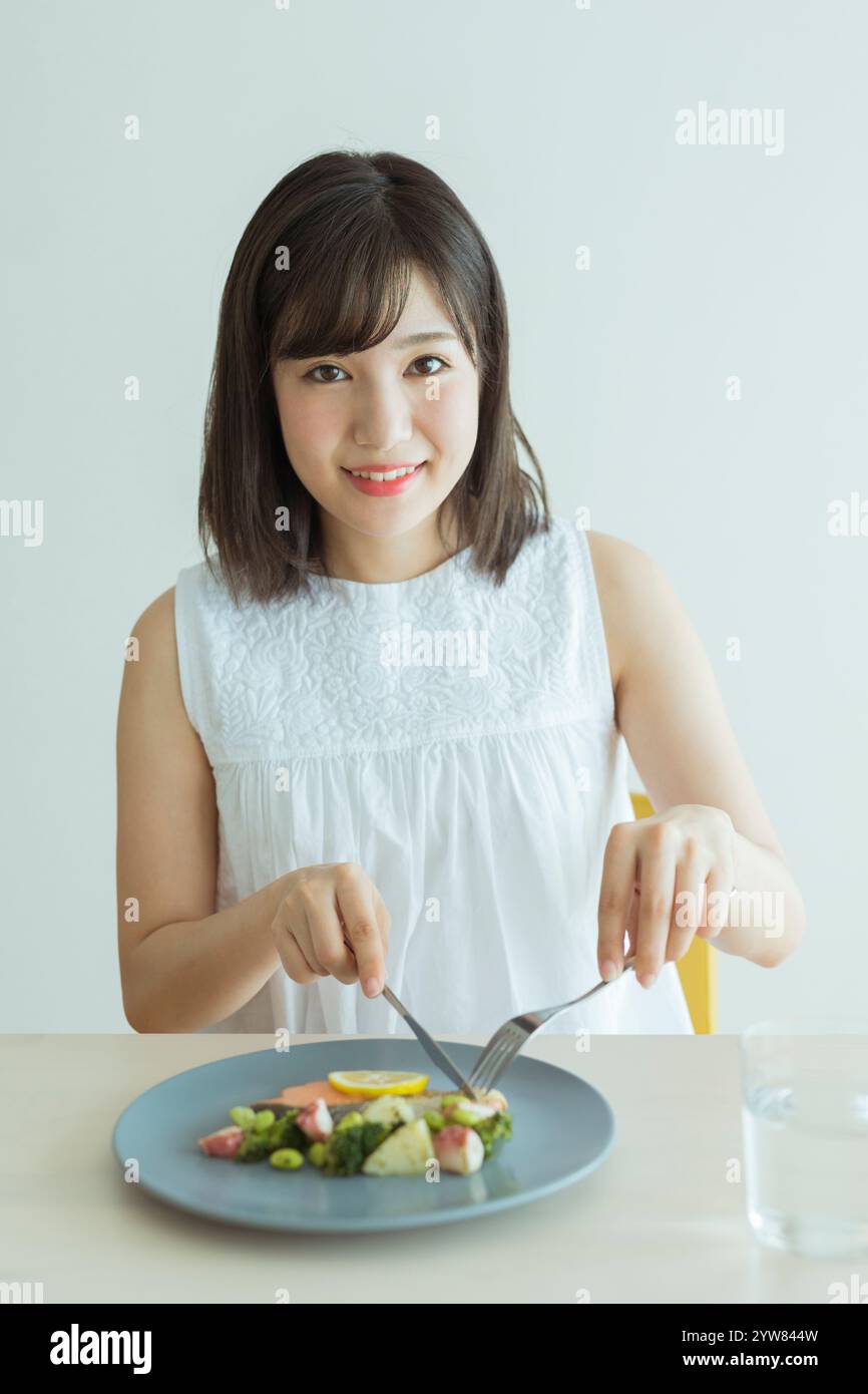 Woman eating with a smile Stock Photo - Alamy