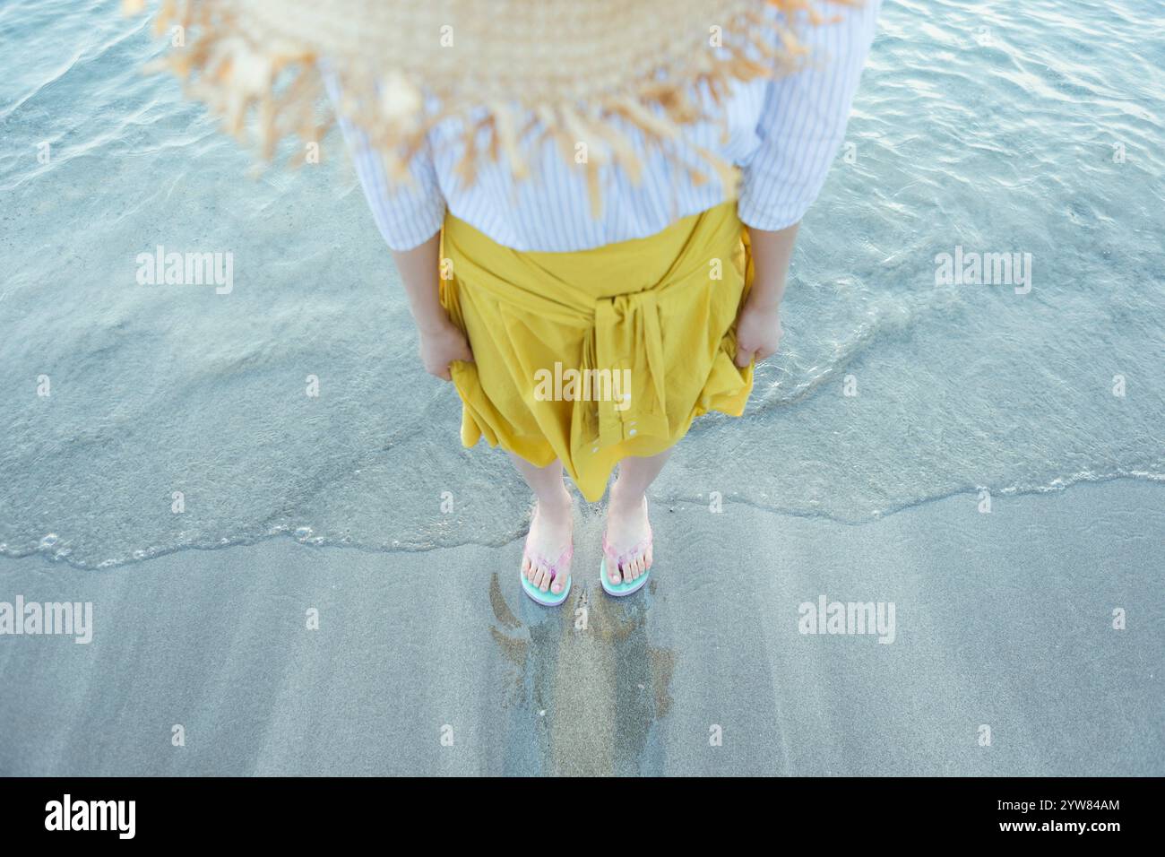 Woman standing still on the beach Stock Photo - Alamy