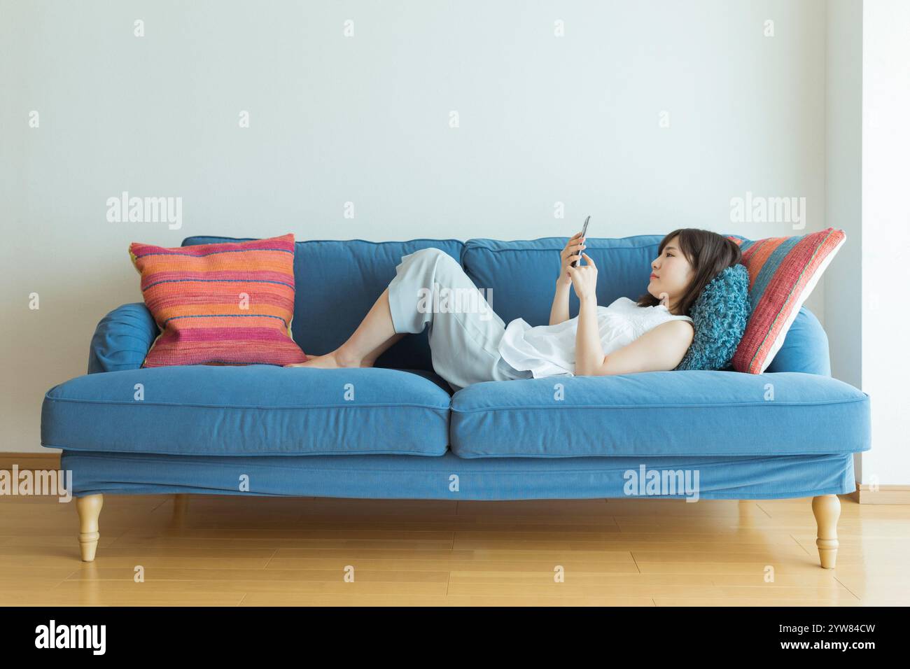 Woman operating a smartphone lying down Stock Photo - Alamy