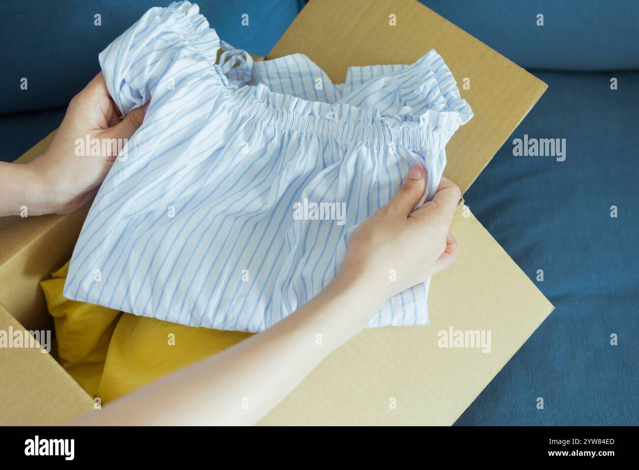 Woman picking up clothes Stock Photo - Alamy