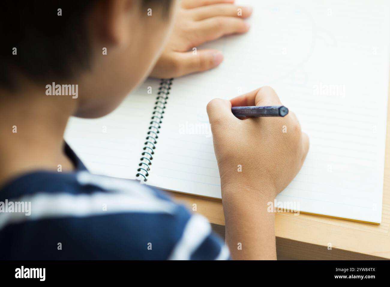 Hand of a boy of primary school age writing a picture Stock Photo - Alamy