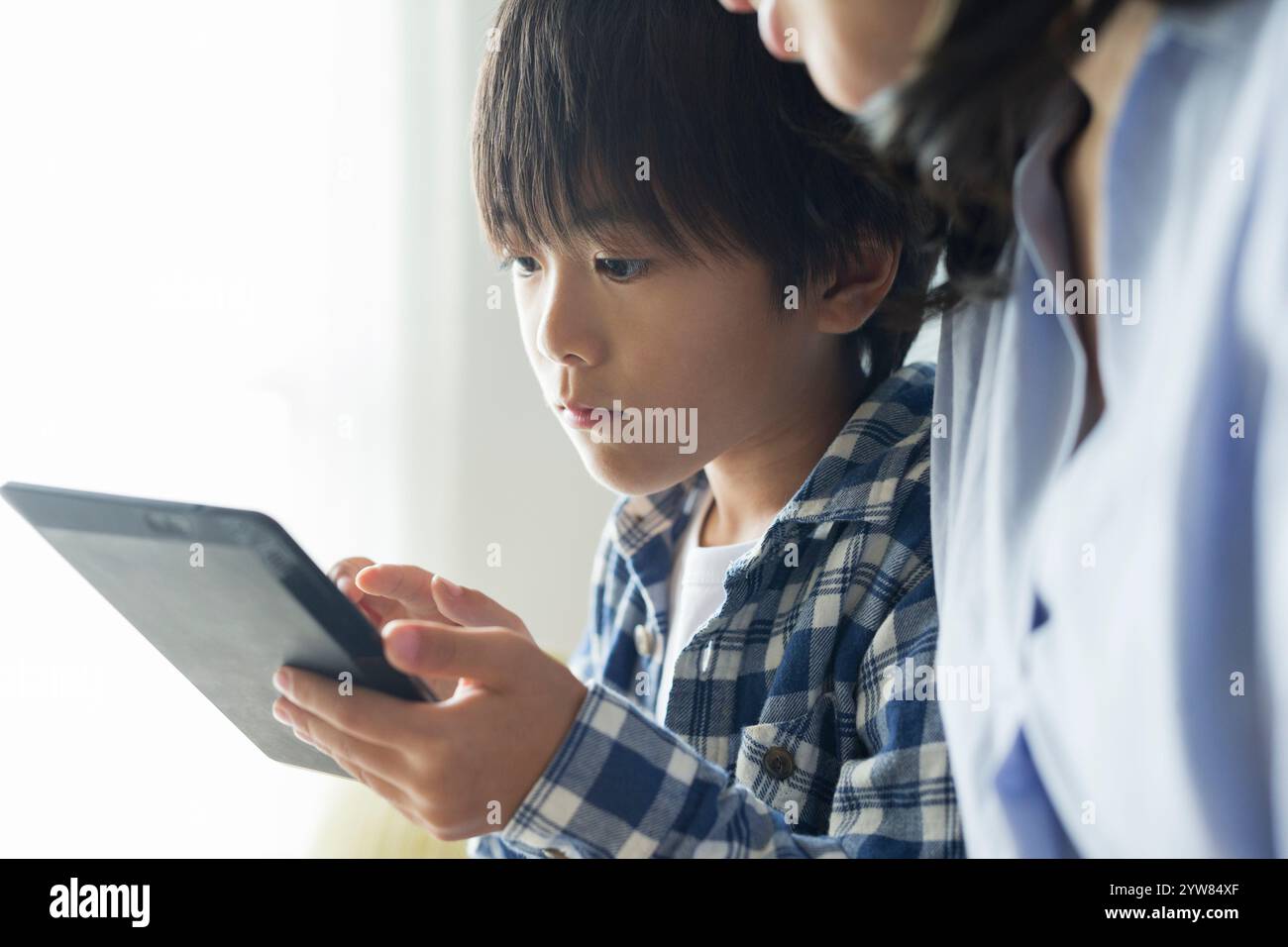 Woman and boys operating tablet Stock Photo - Alamy