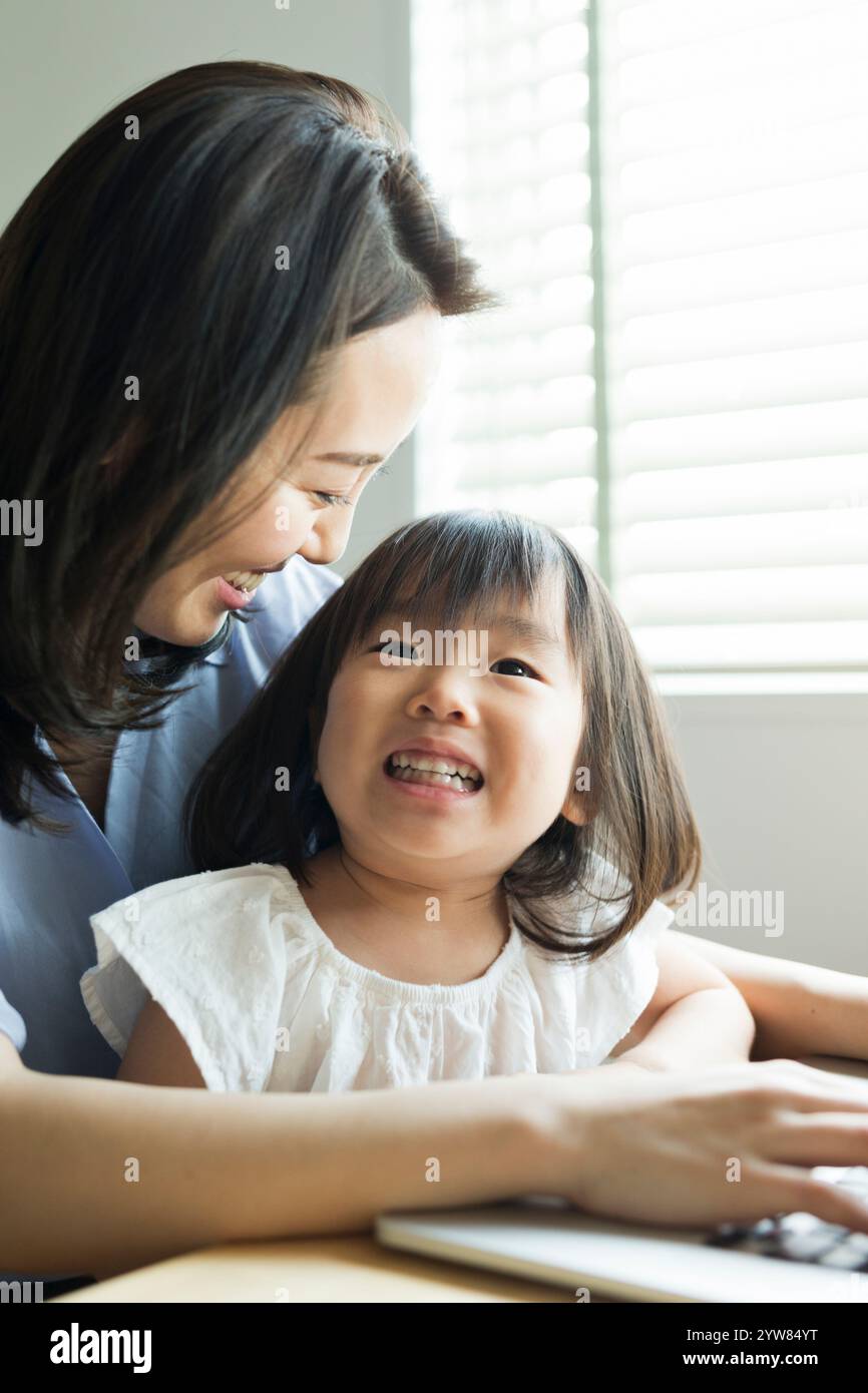 Woman and girl operating a computer Stock Photo - Alamy