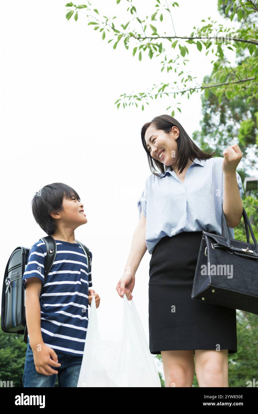 Smiling parent and child talking while carrying shopping bags together ...