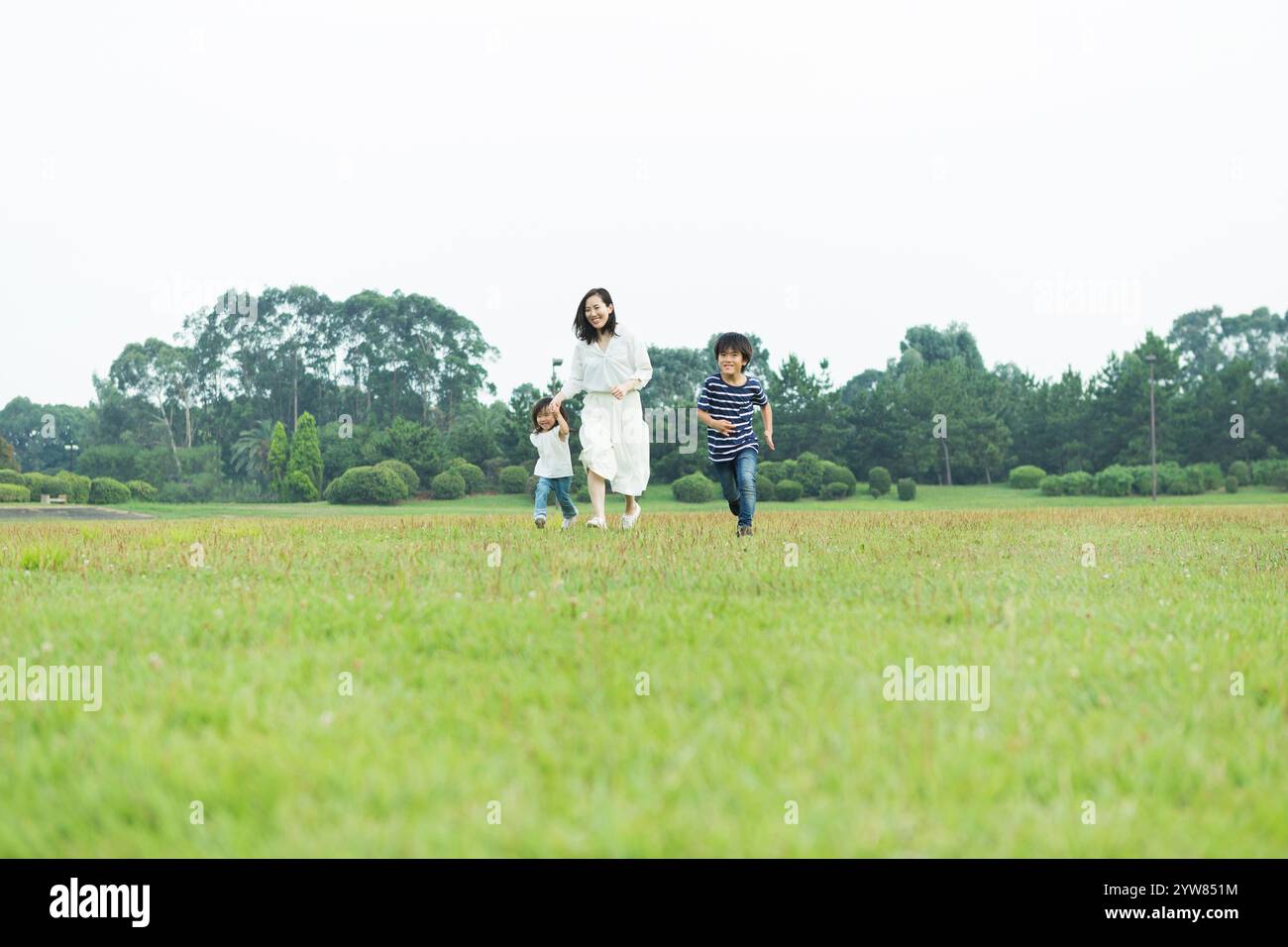 Parent and child running hand in hand with a smile Stock Photo - Alamy