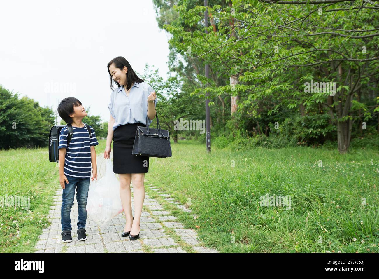 Smiling parent and child talking while carrying shopping bags together ...