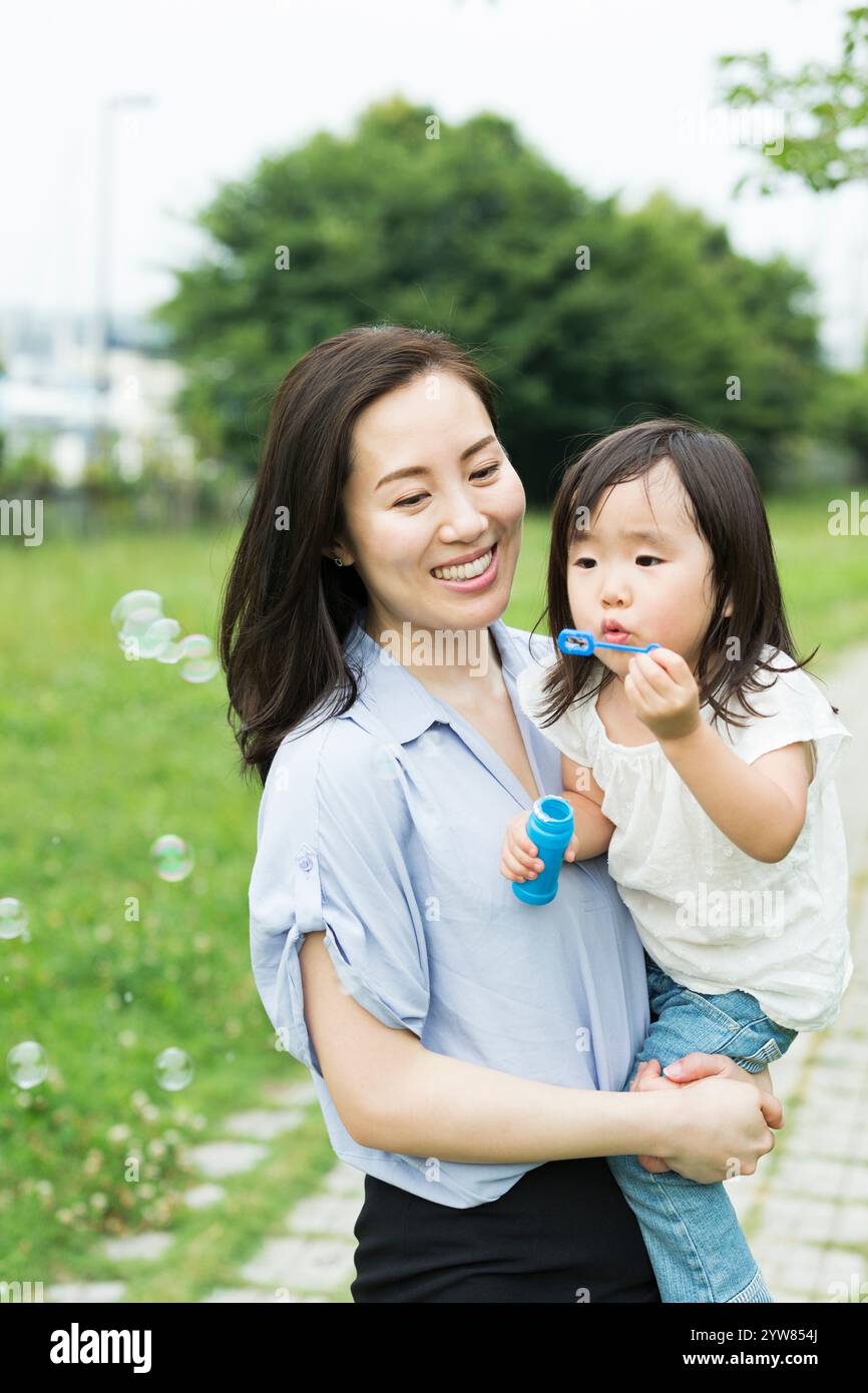Parent and child playing with soap bubbles Stock Photo - Alamy