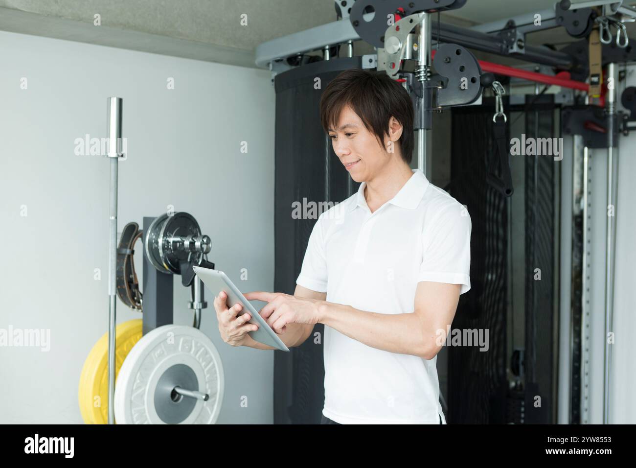 Male trainer operating tablet Stock Photo - Alamy