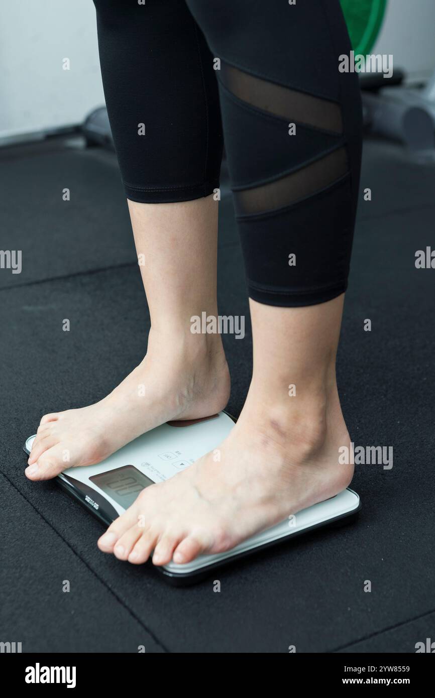 Woman's feet on the scale Stock Photo - Alamy