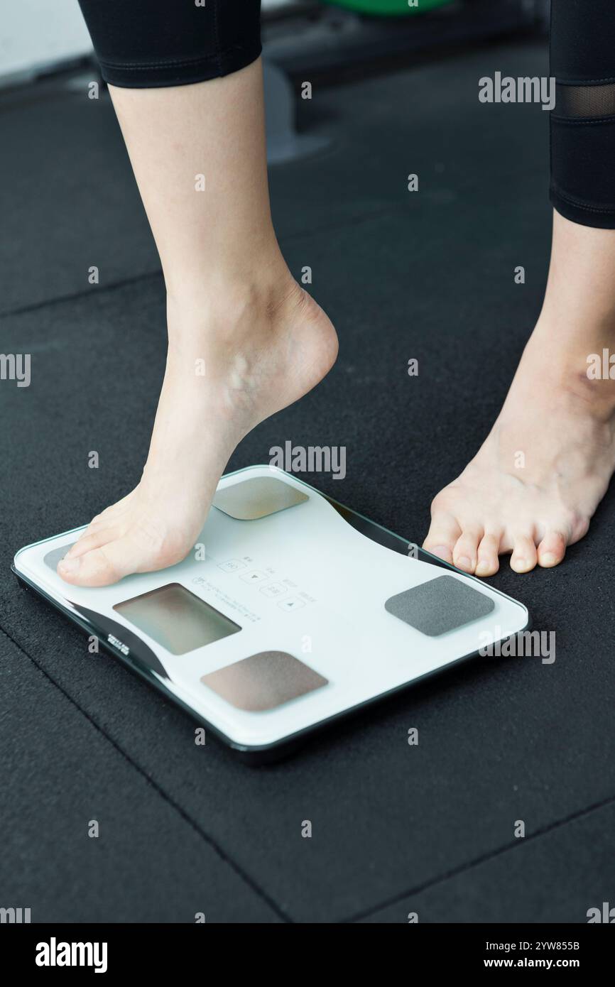 Woman's feet on the scale Stock Photo - Alamy