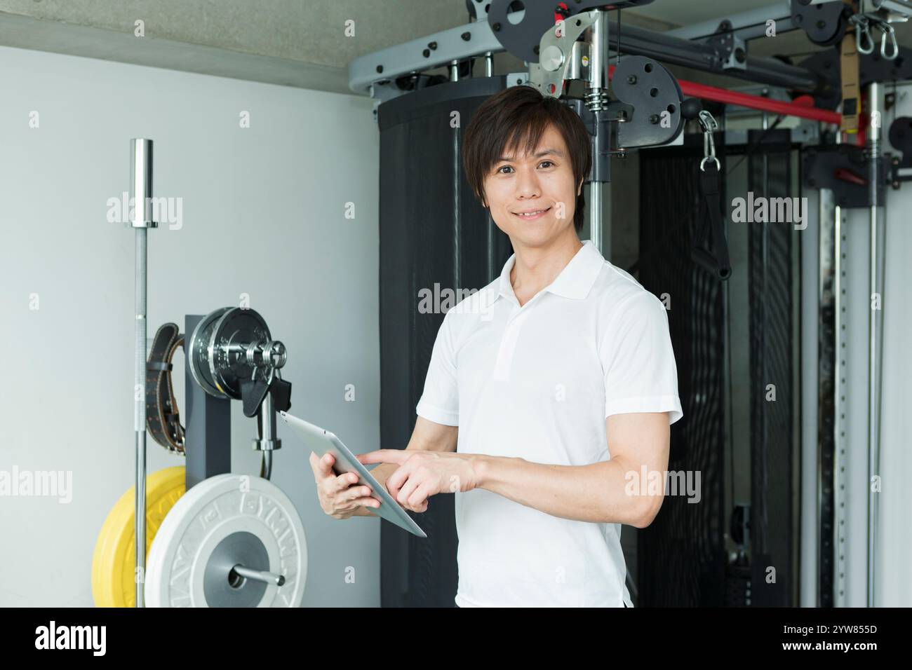 Male trainer operating tablet Stock Photo - Alamy
