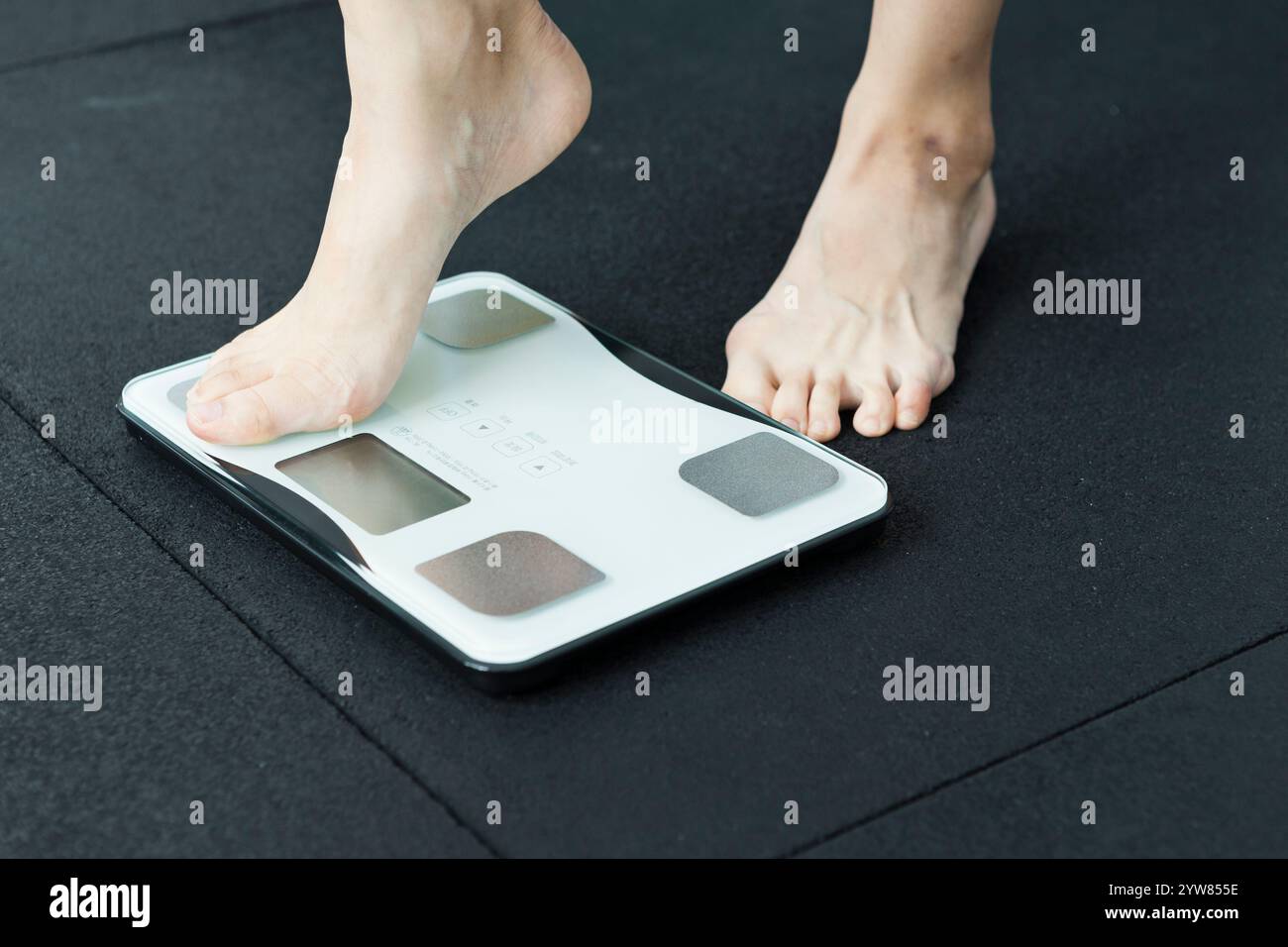 Woman's feet on the scale Stock Photo - Alamy