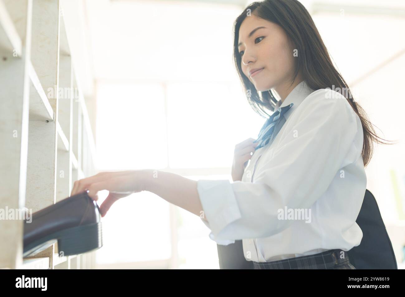 High school girl putting shoes into geta box Stock Photo - Alamy