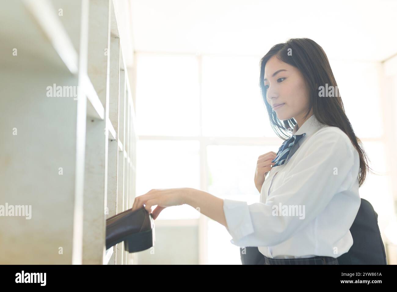 High school girl putting shoes into geta box Stock Photo - Alamy