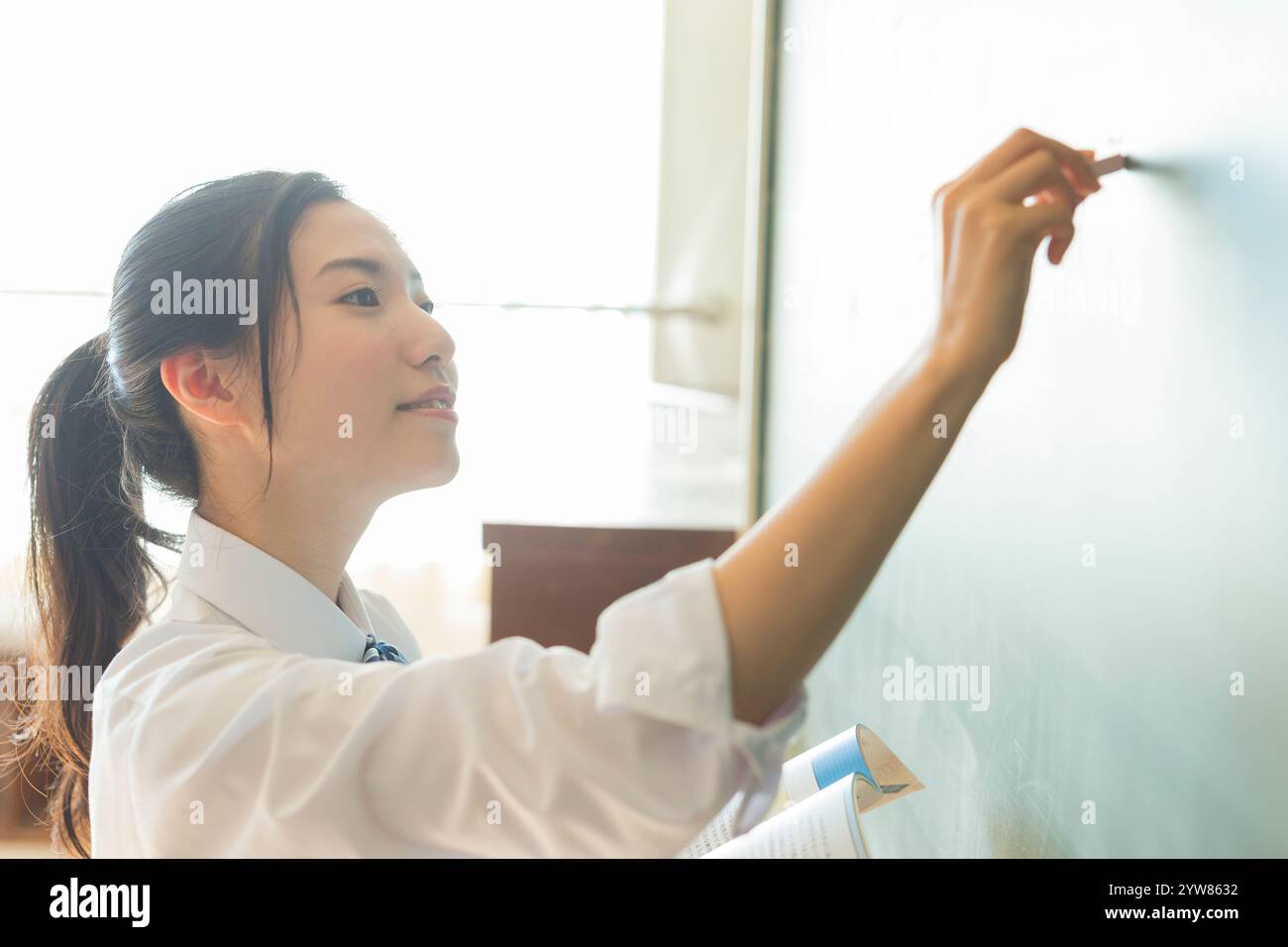 Female high school student filling in on the blackboard Stock Photo - Alamy