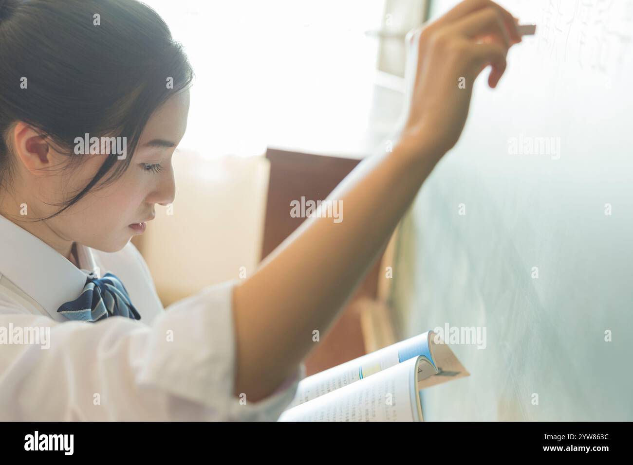 Female high school student filling in on the blackboard Stock Photo - Alamy