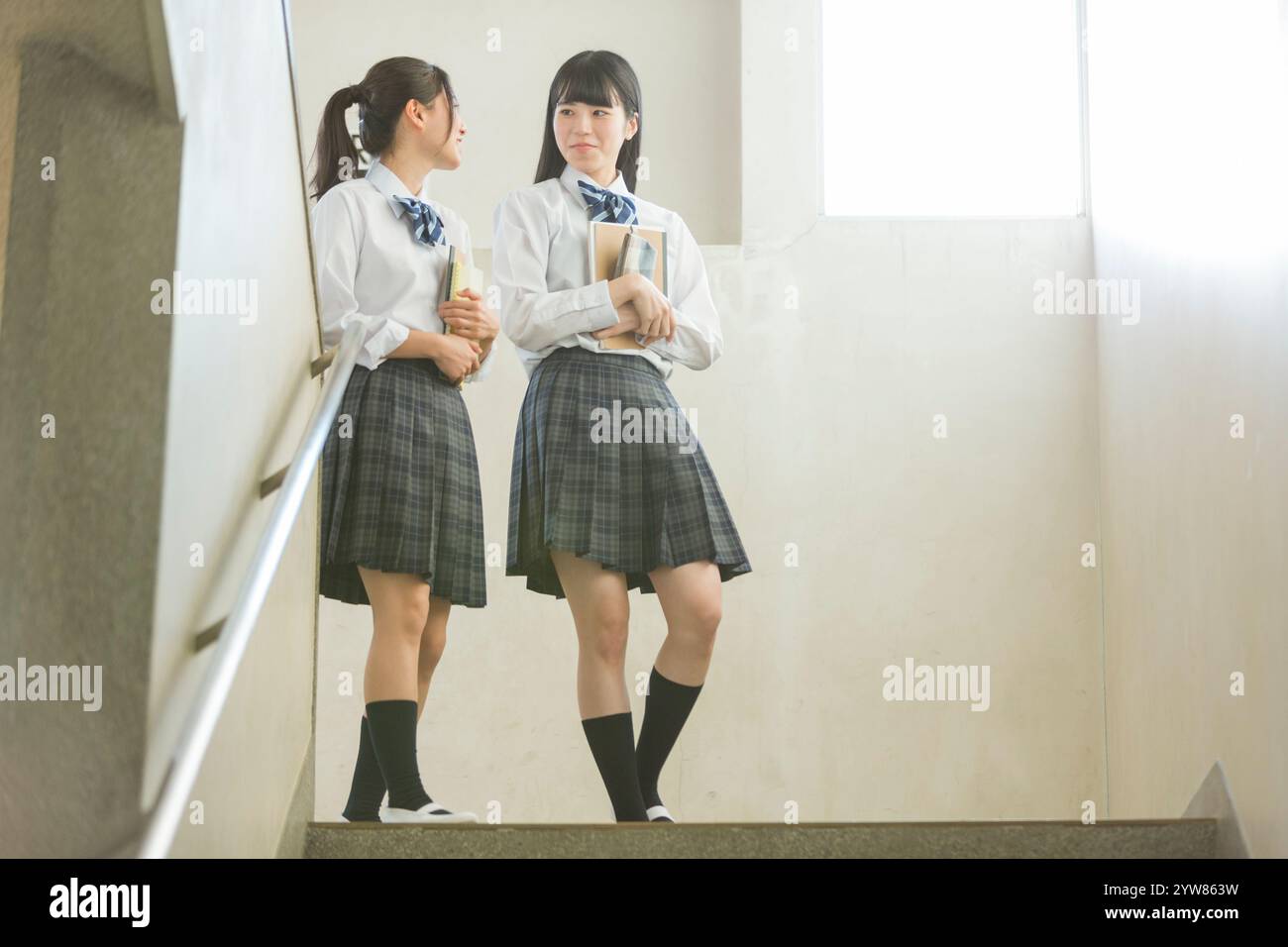 Female high school student conversing on stairs Stock Photo - Alamy
