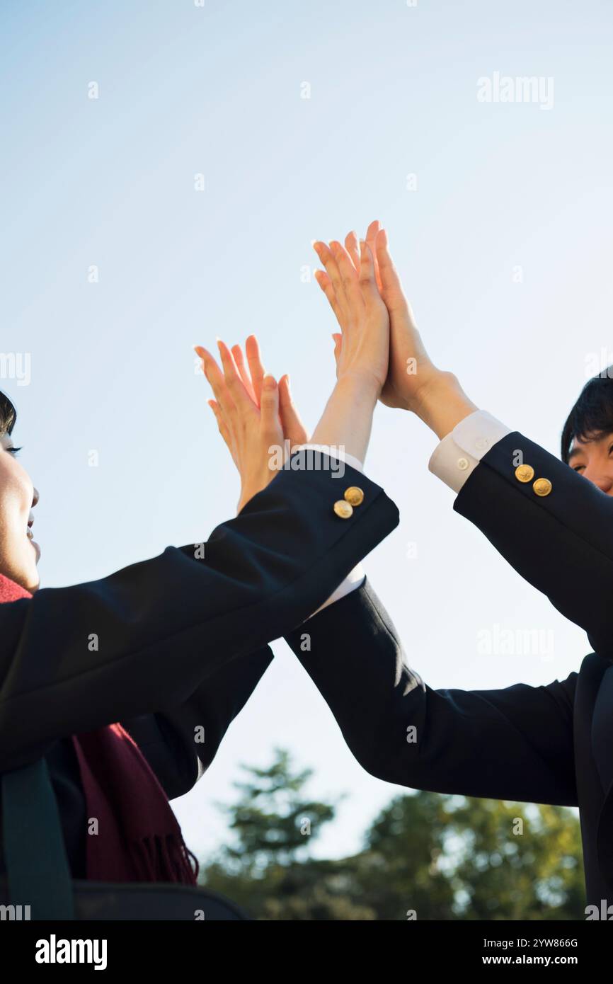 Male and female high school students high-fiving Stock Photo - Alamy