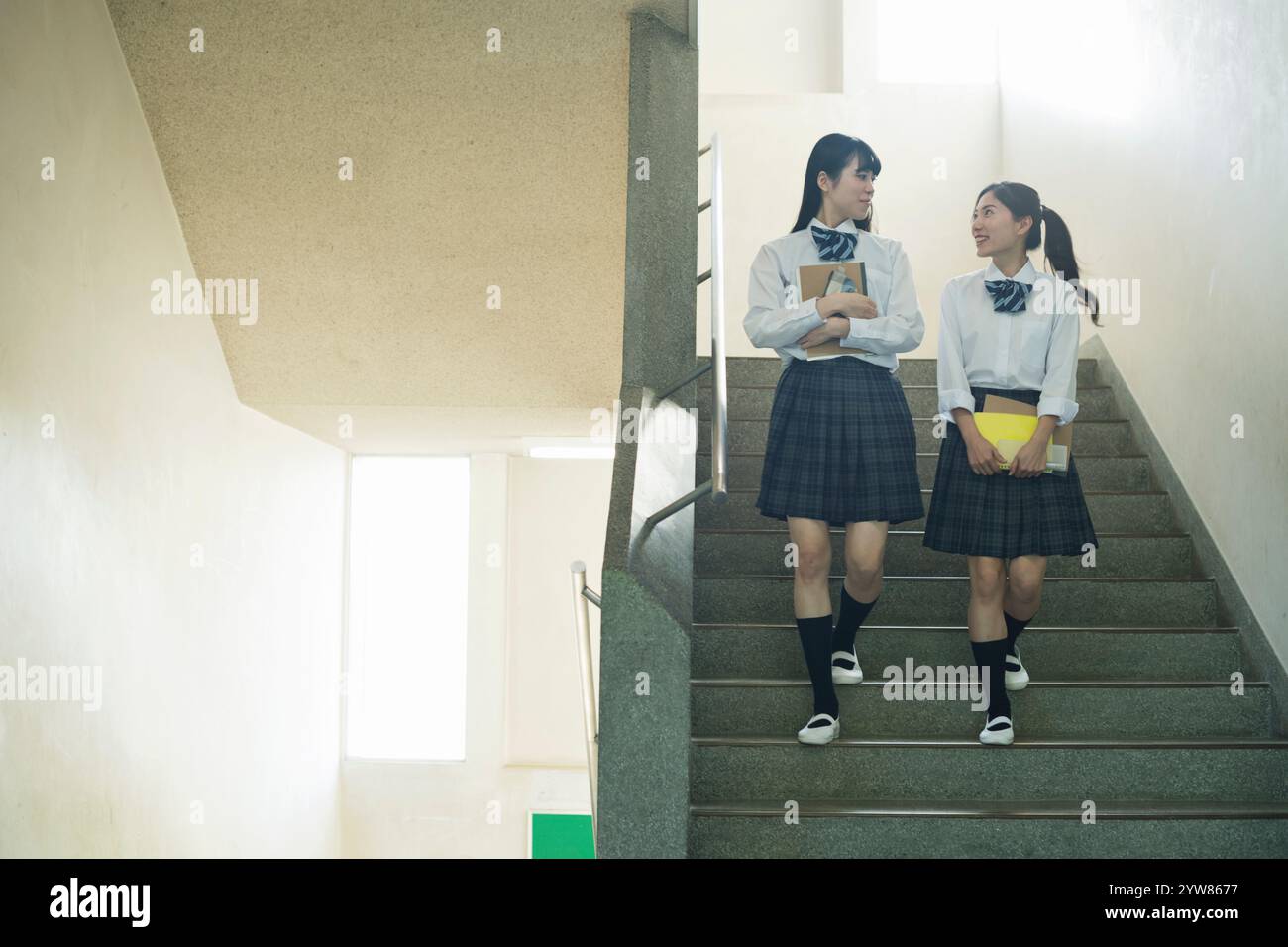 Female high school student conversing on stairs Stock Photo - Alamy