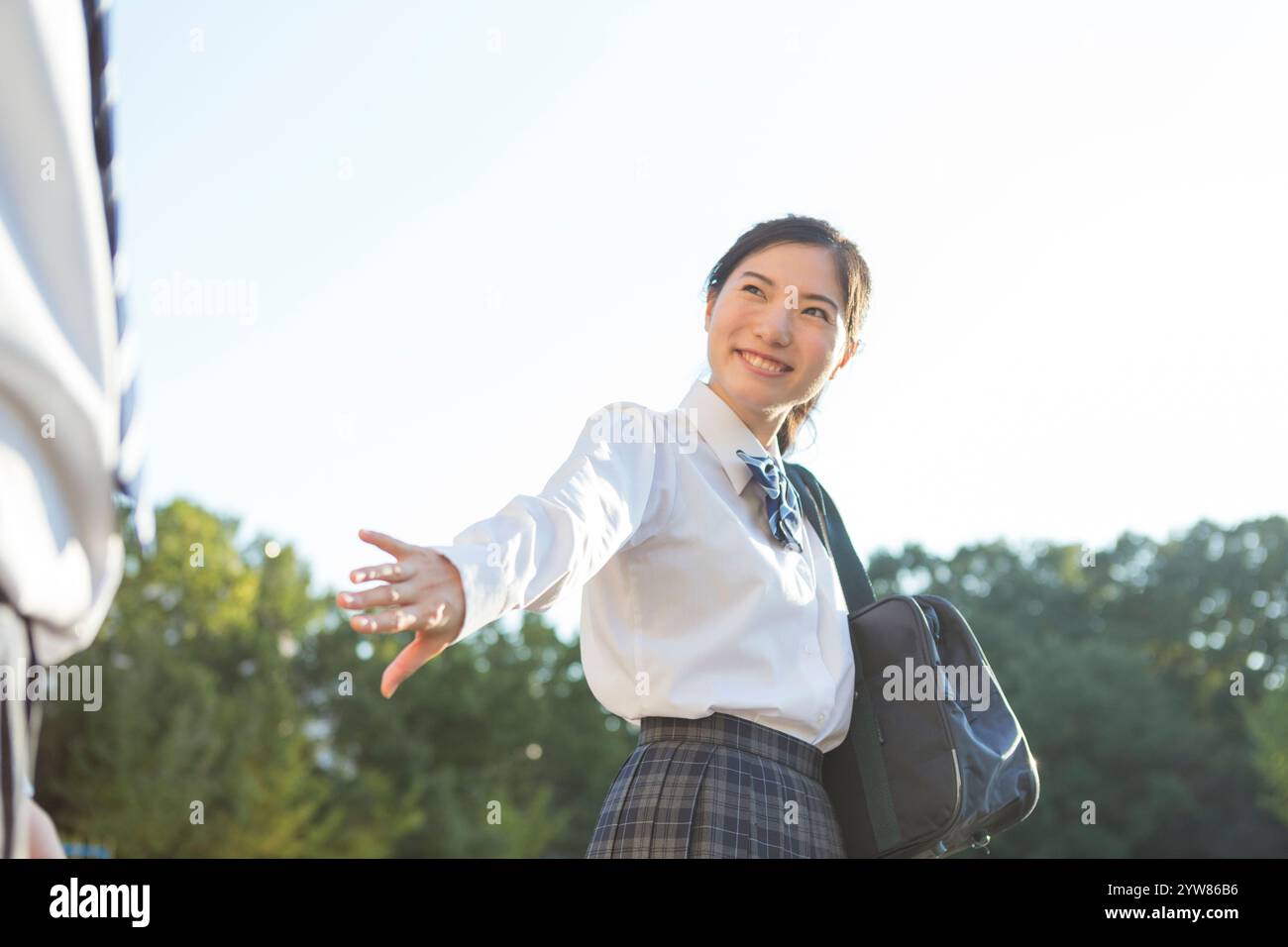 Smiling high school girl reaching out Stock Photo - Alamy
