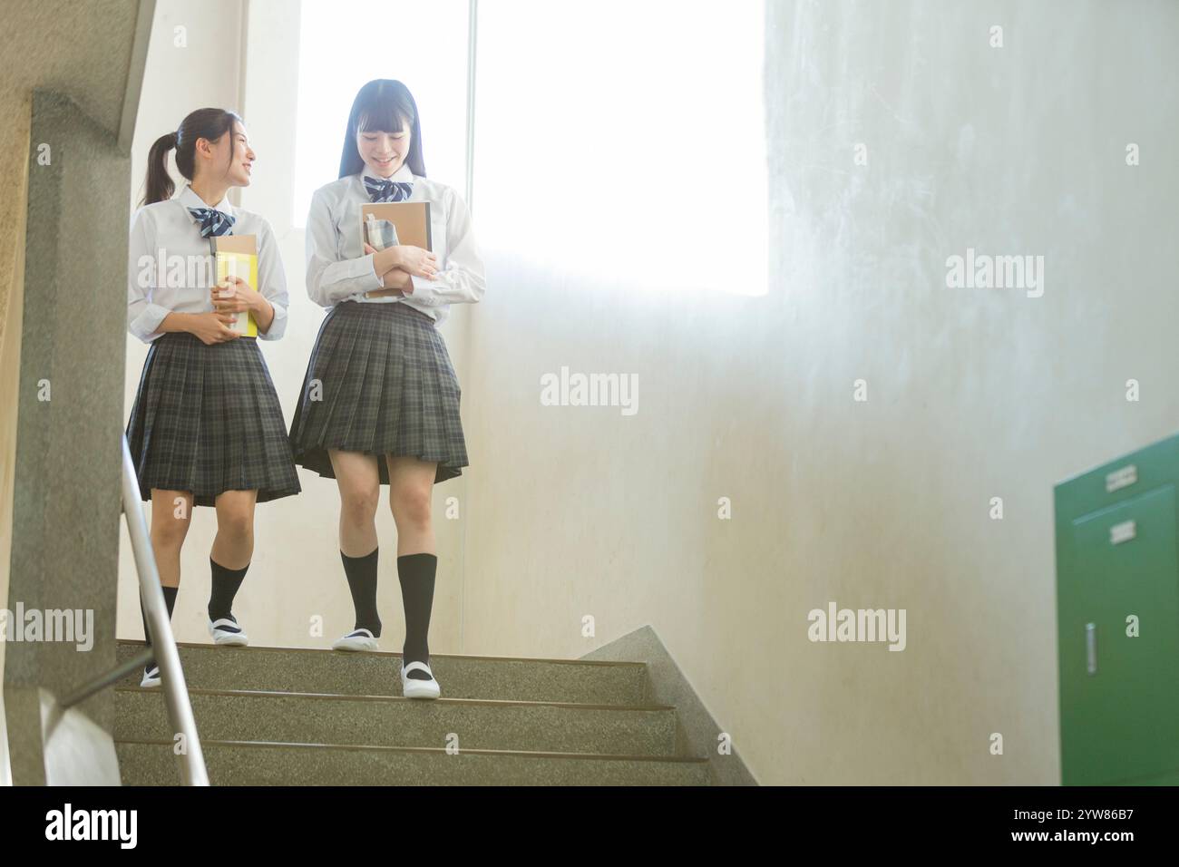 Female high school student conversing on stairs Stock Photo - Alamy