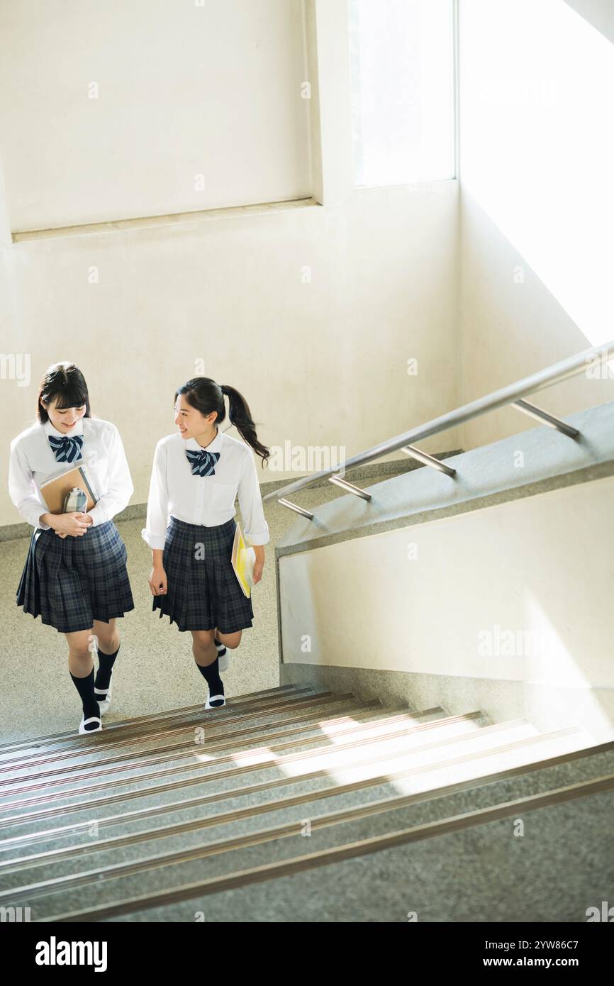 Female high school student conversing on stairs Stock Photo - Alamy