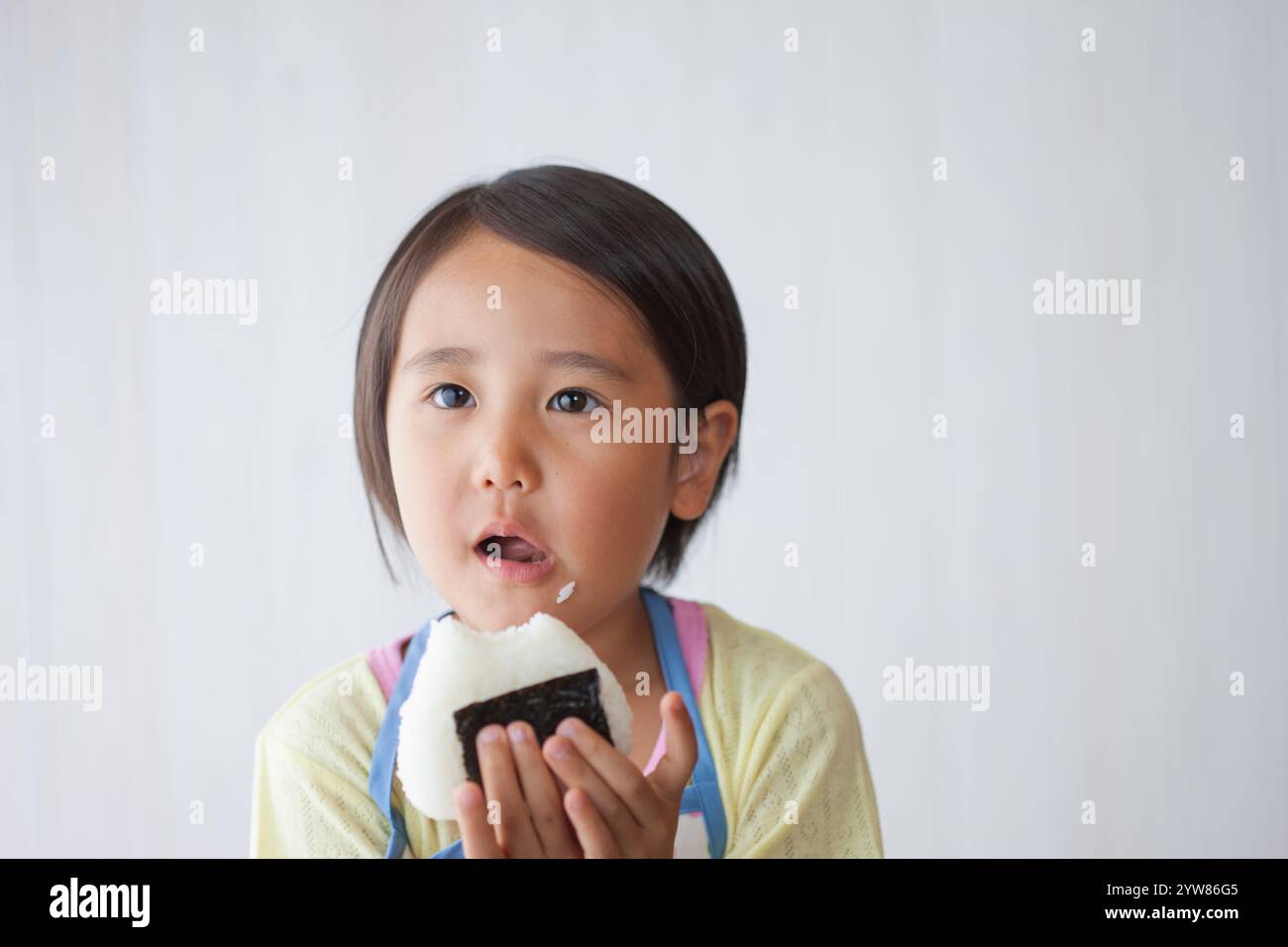 Girl eating omusubi Stock Photo - Alamy