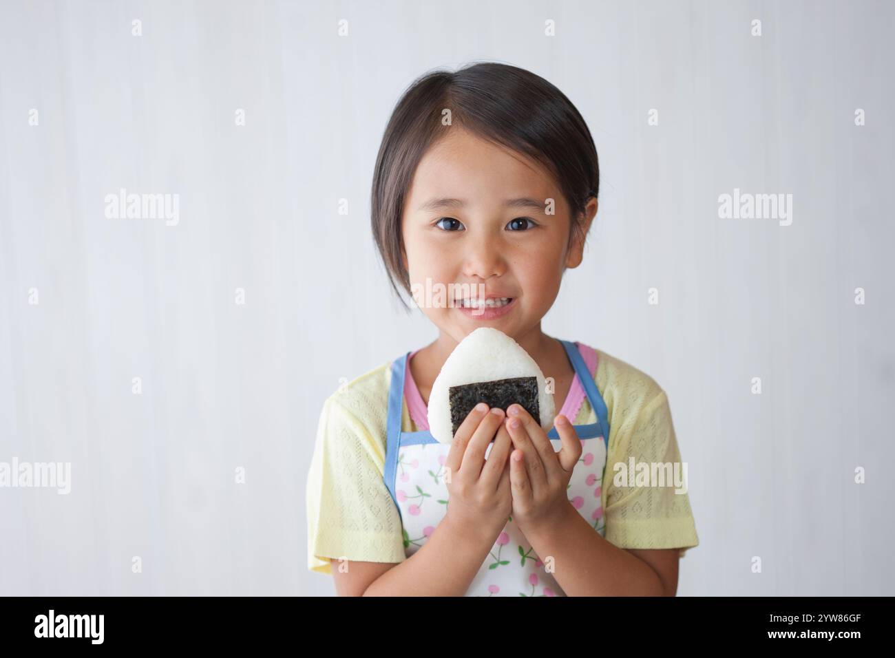 Girl eating omusubi Stock Photo - Alamy