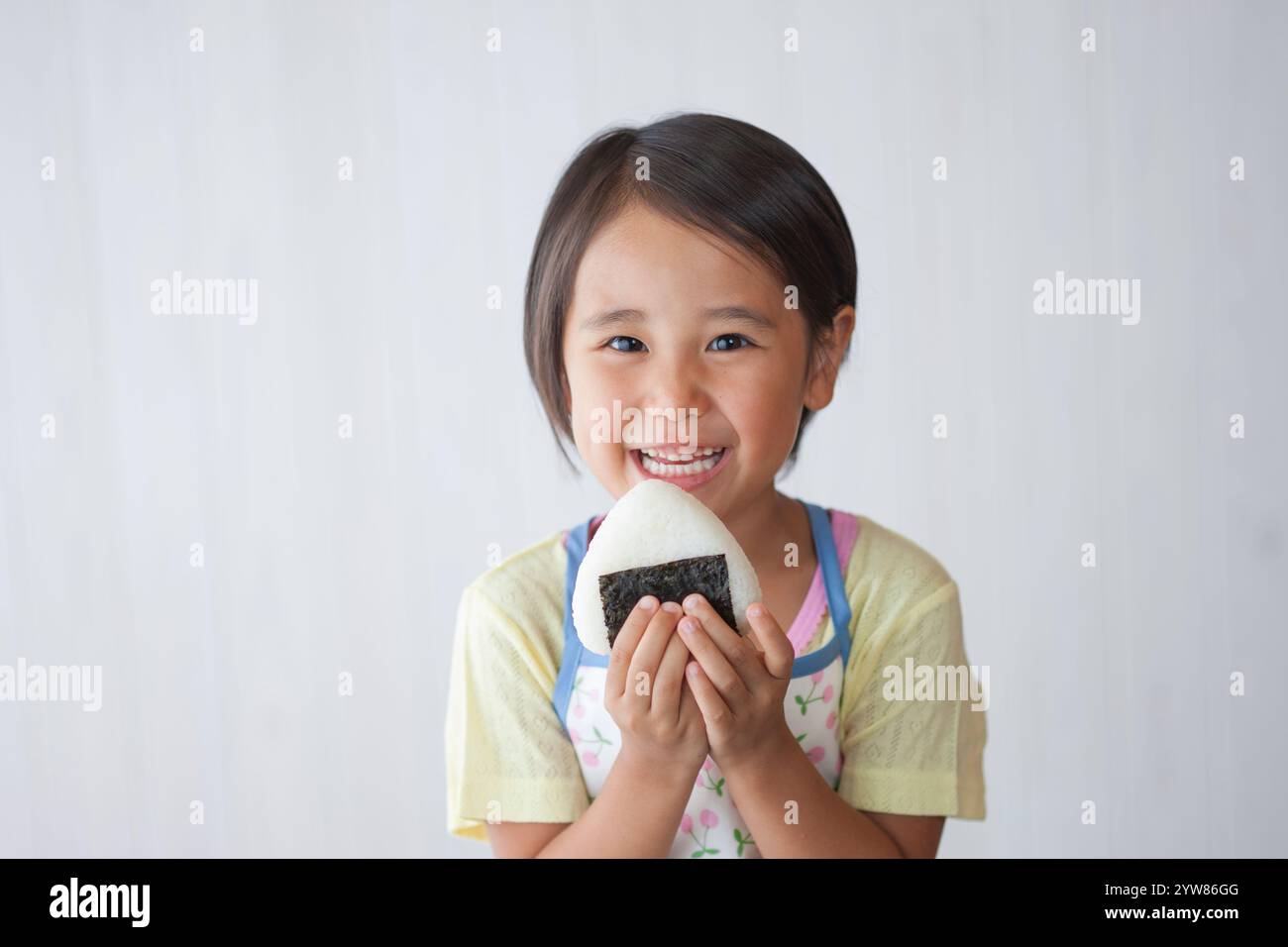 Girl eating omusubi Stock Photo - Alamy