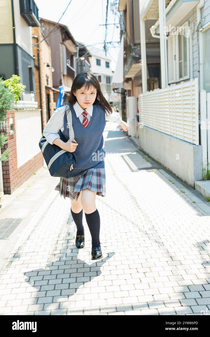 Female high school student leaving school in front of the entrance ...