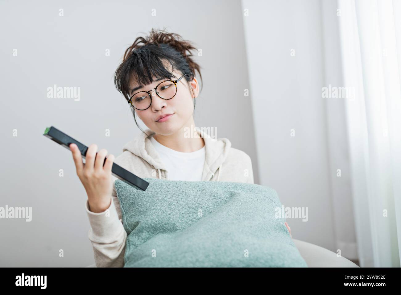 Woman Remote control operation Stock Photo - Alamy