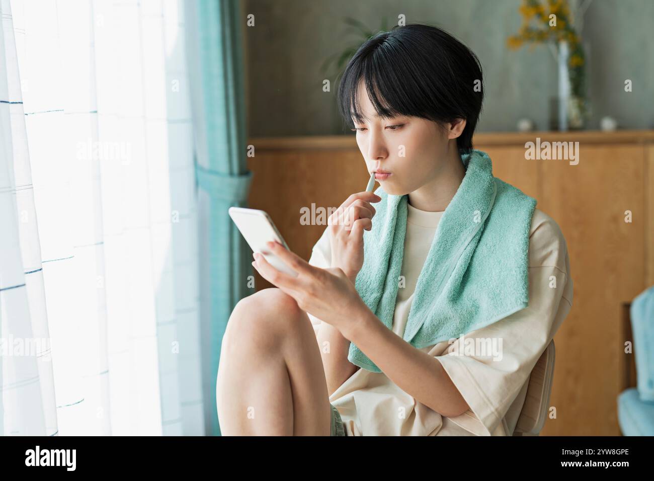 Woman looking at mobile phone while brushing teeth Stock Photo - Alamy