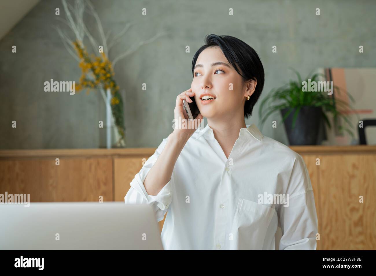 Woman taking a phone call while working remotely Stock Photo - Alamy