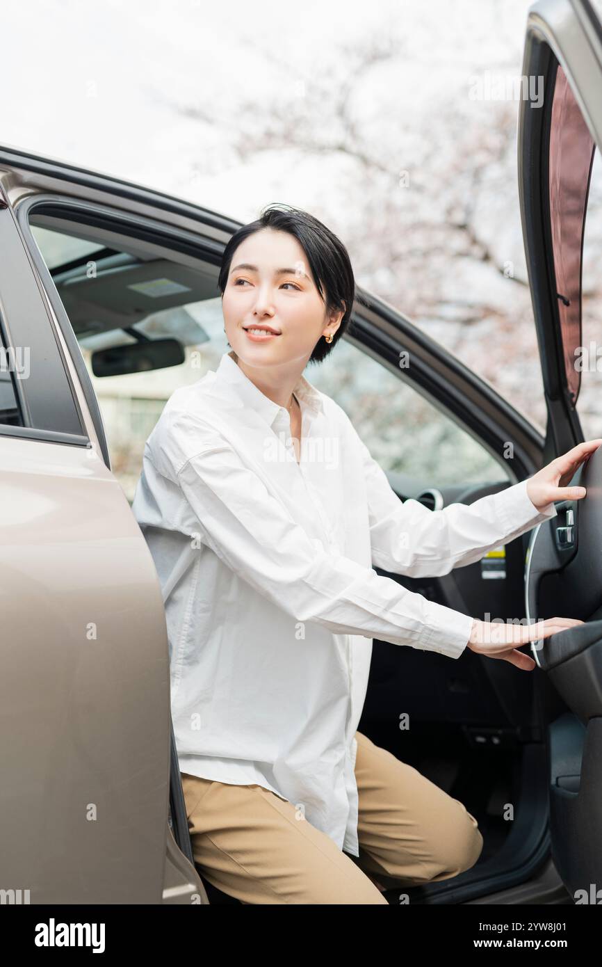 Woman getting out of car Stock Photo - Alamy