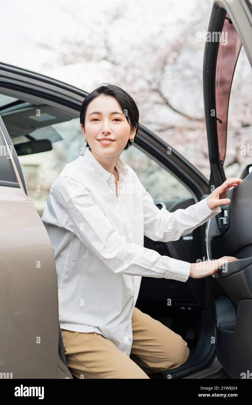 Woman getting out of car Stock Photo - Alamy