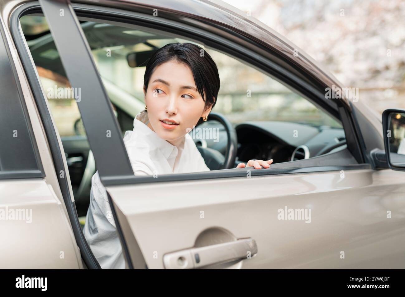 Woman getting out of car Stock Photo - Alamy