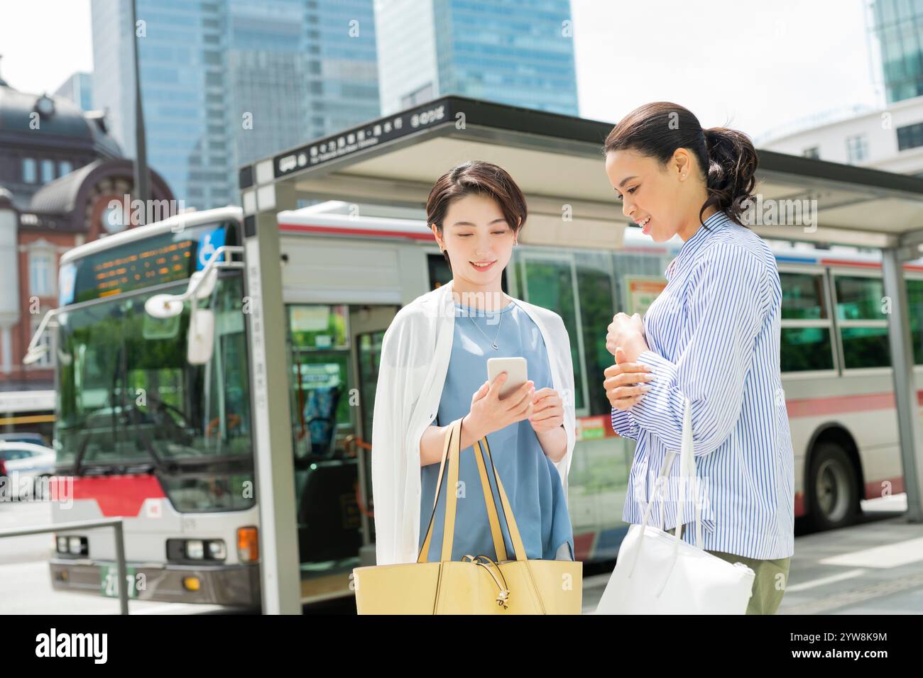 Two women waiting for the bus Stock Photo - Alamy