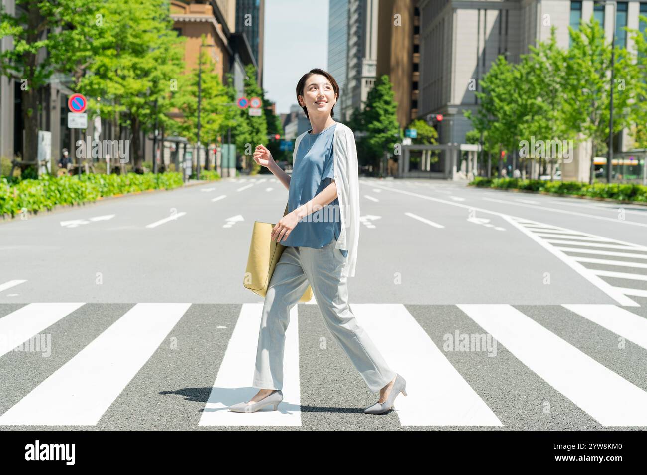 Woman crossing at pedestrian crossing Stock Photo - Alamy