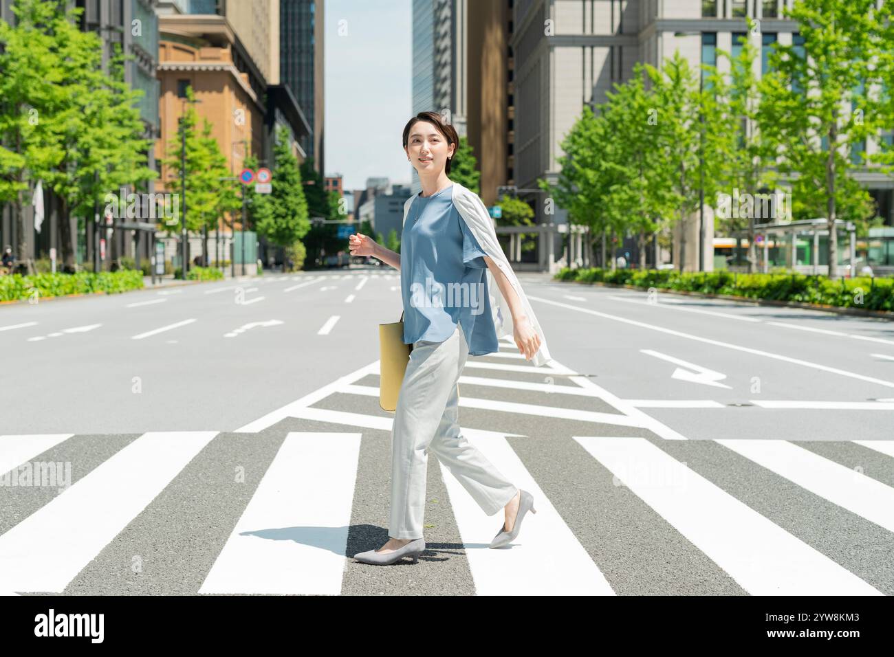 Woman crossing at pedestrian crossing Stock Photo - Alamy