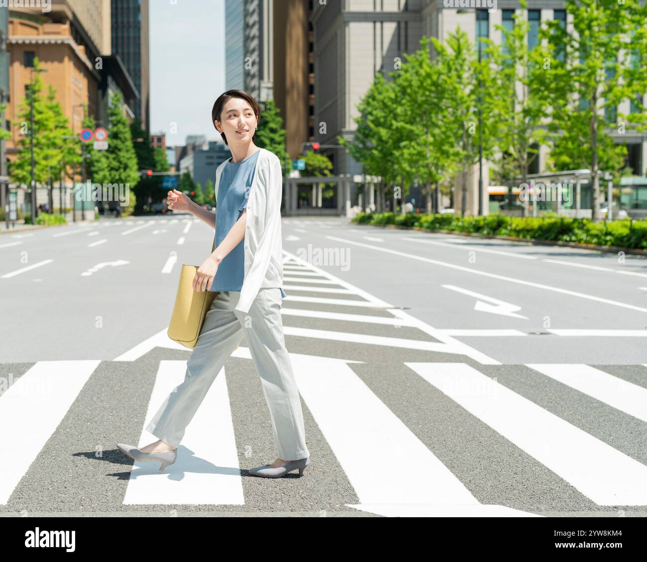 Woman crossing at pedestrian crossing Stock Photo - Alamy