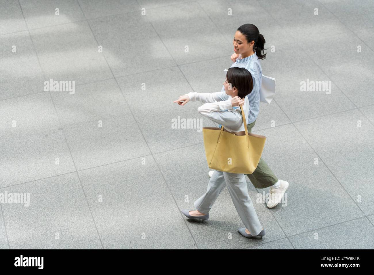 Two women walking inside a building Stock Photo - Alamy