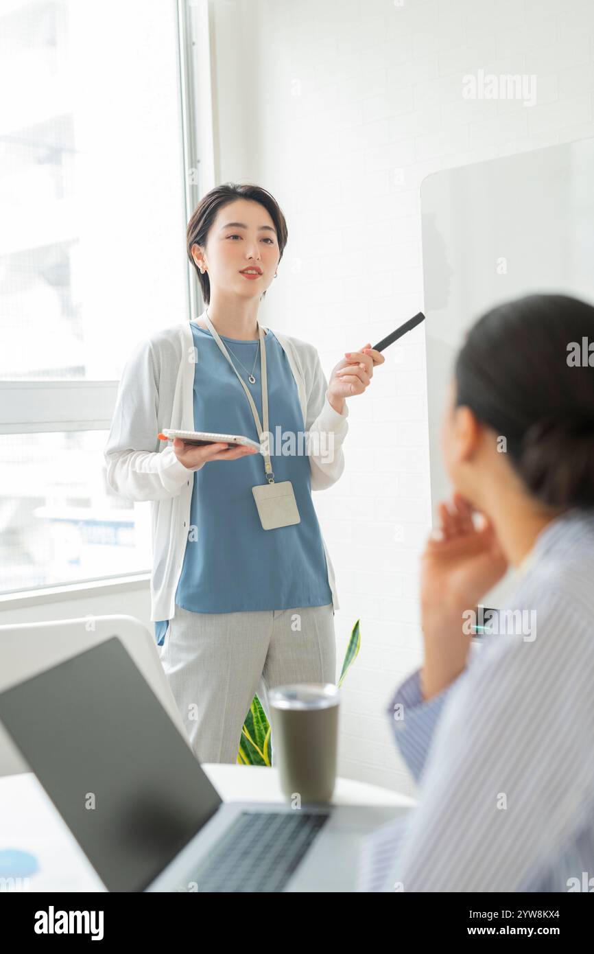 Two women giving a presentation in an office Stock Photo - Alamy