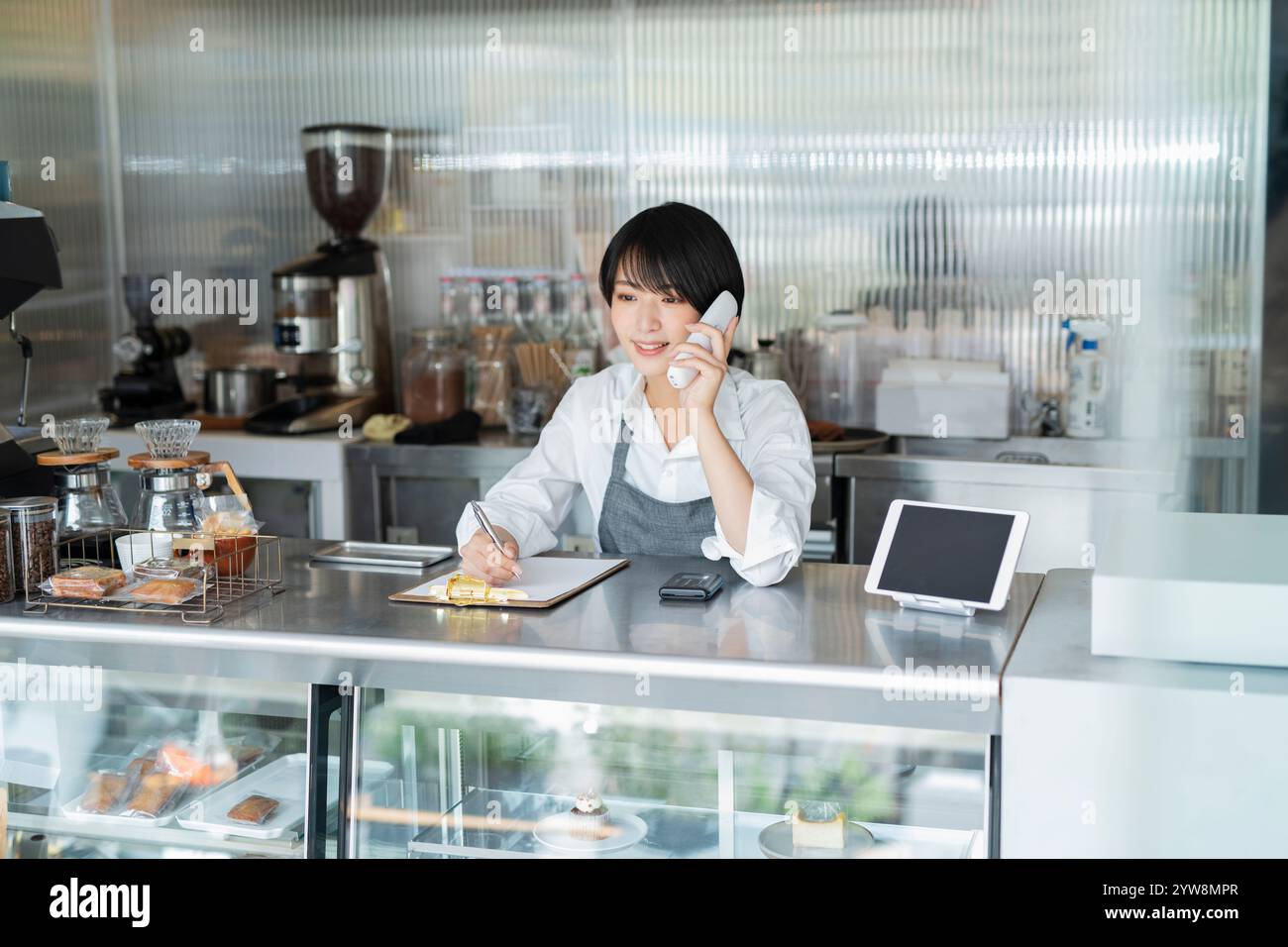 Café Female staff making a phone call Stock Photo - Alamy