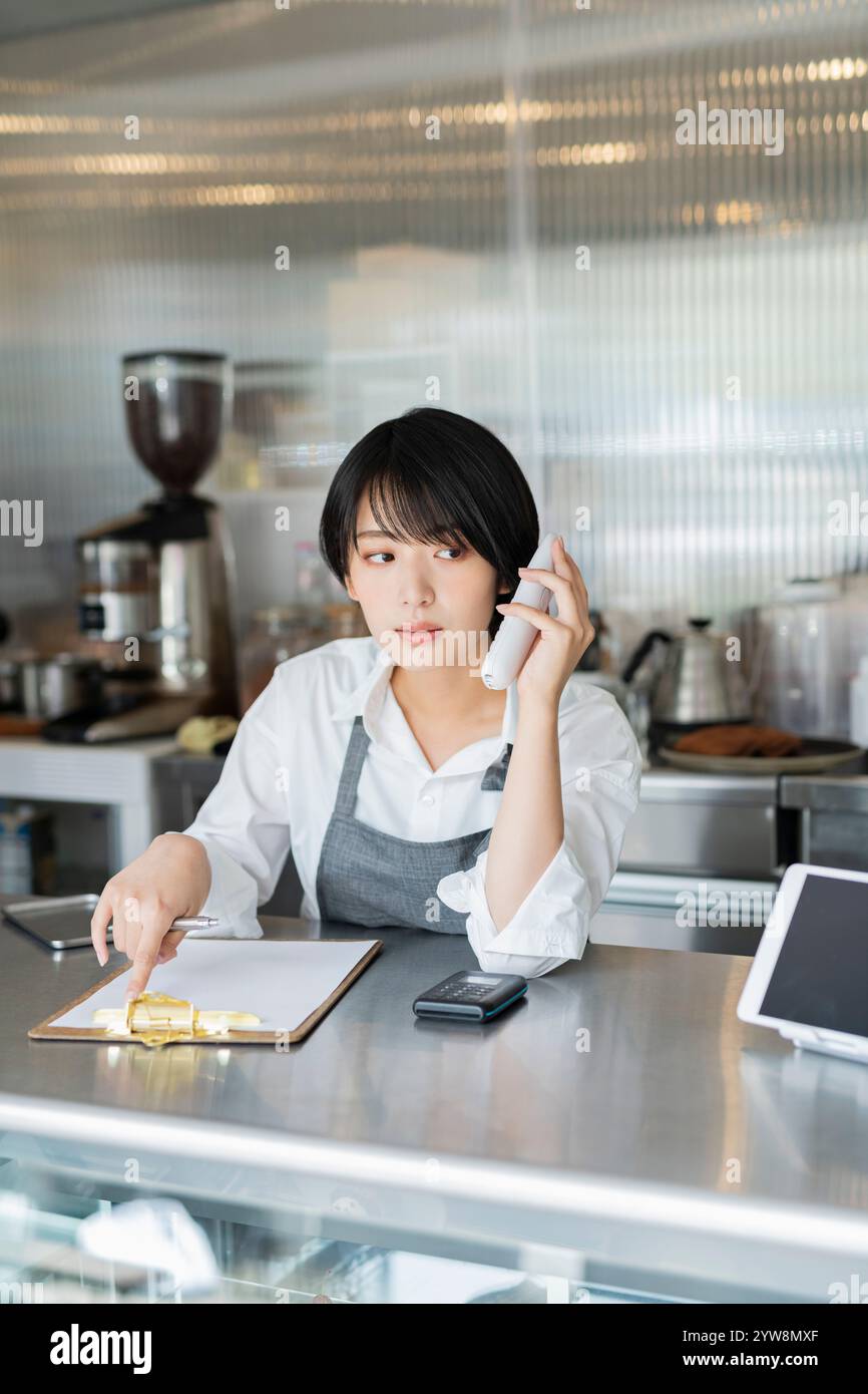 Café Female staff making a phone call Stock Photo - Alamy