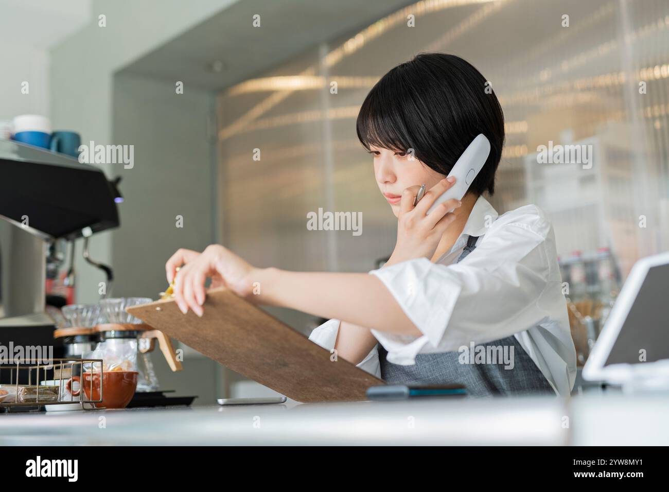 Café Female staff making a phone call Stock Photo - Alamy
