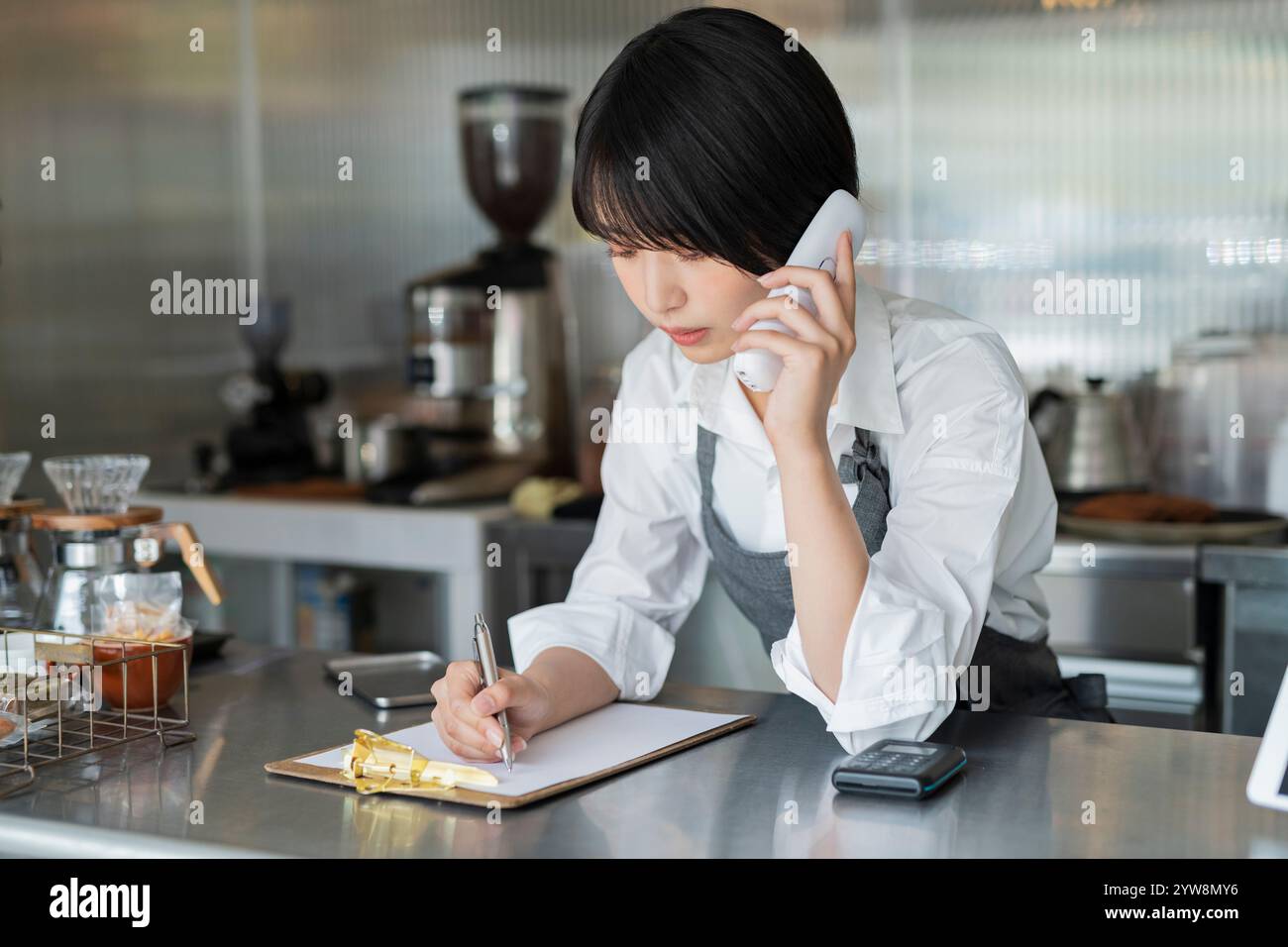 Café Female staff making a phone call Stock Photo - Alamy