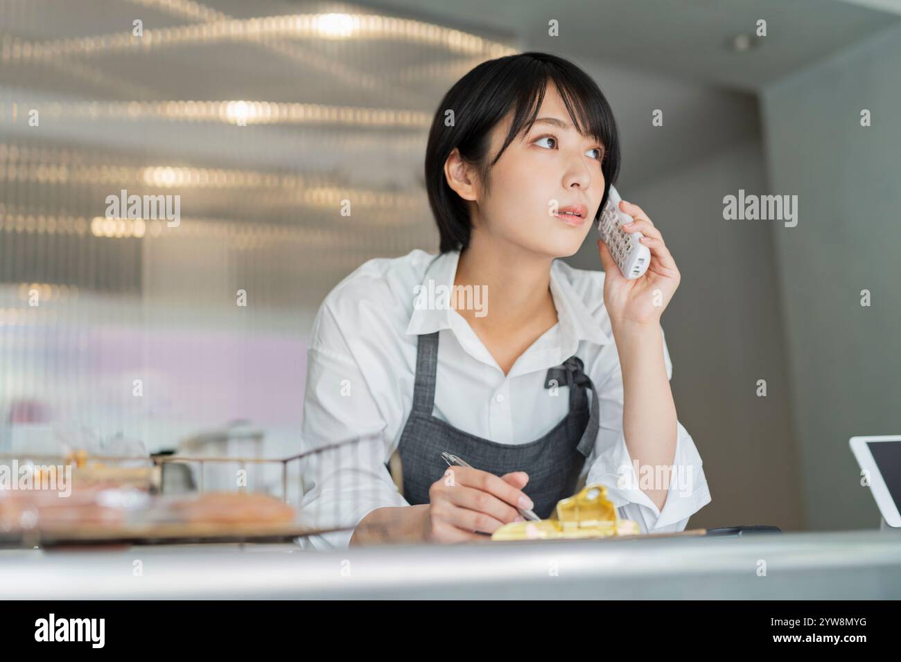 Café Female staff making a phone call Stock Photo - Alamy