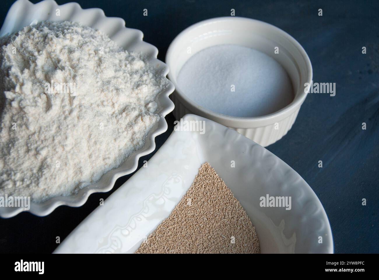 A rustic backdrop with yeast, salt, and flour spread out, highlighting ...